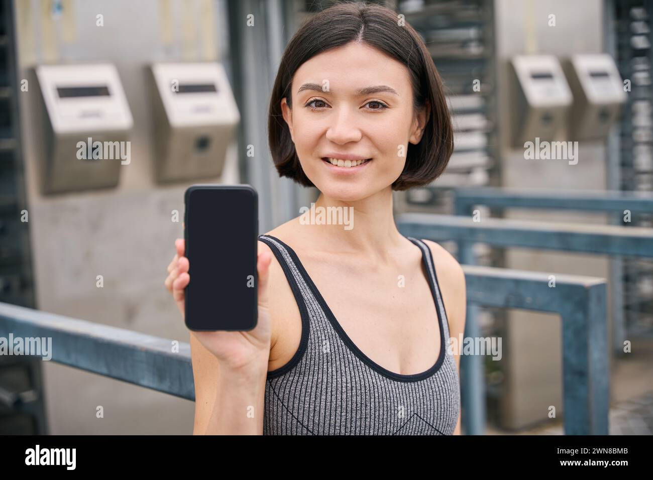 Smiling lady using modern gadget before sport Stock Photo - Alamy