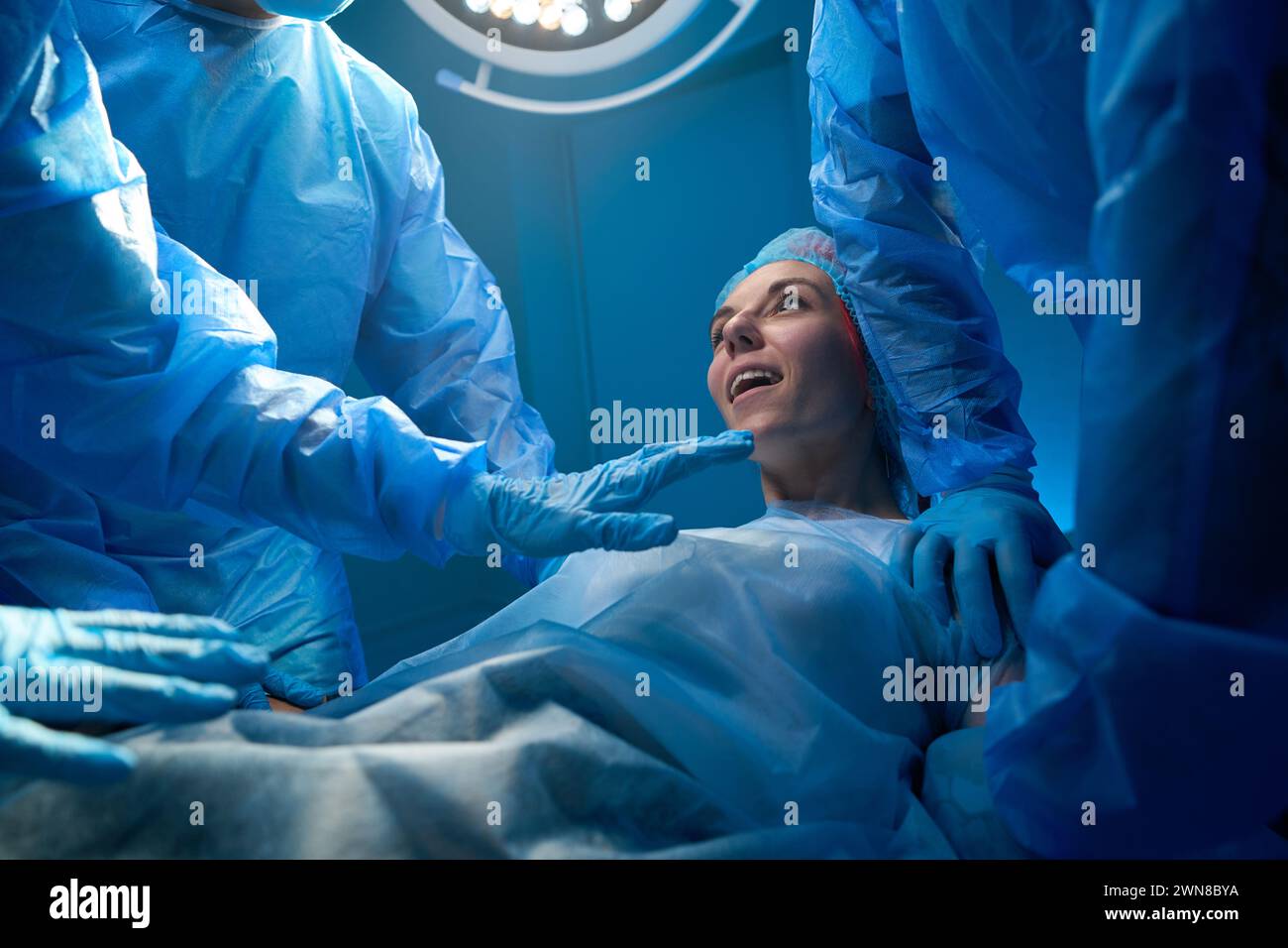 Woman patient waking up on on the operating table in hospital operating ...