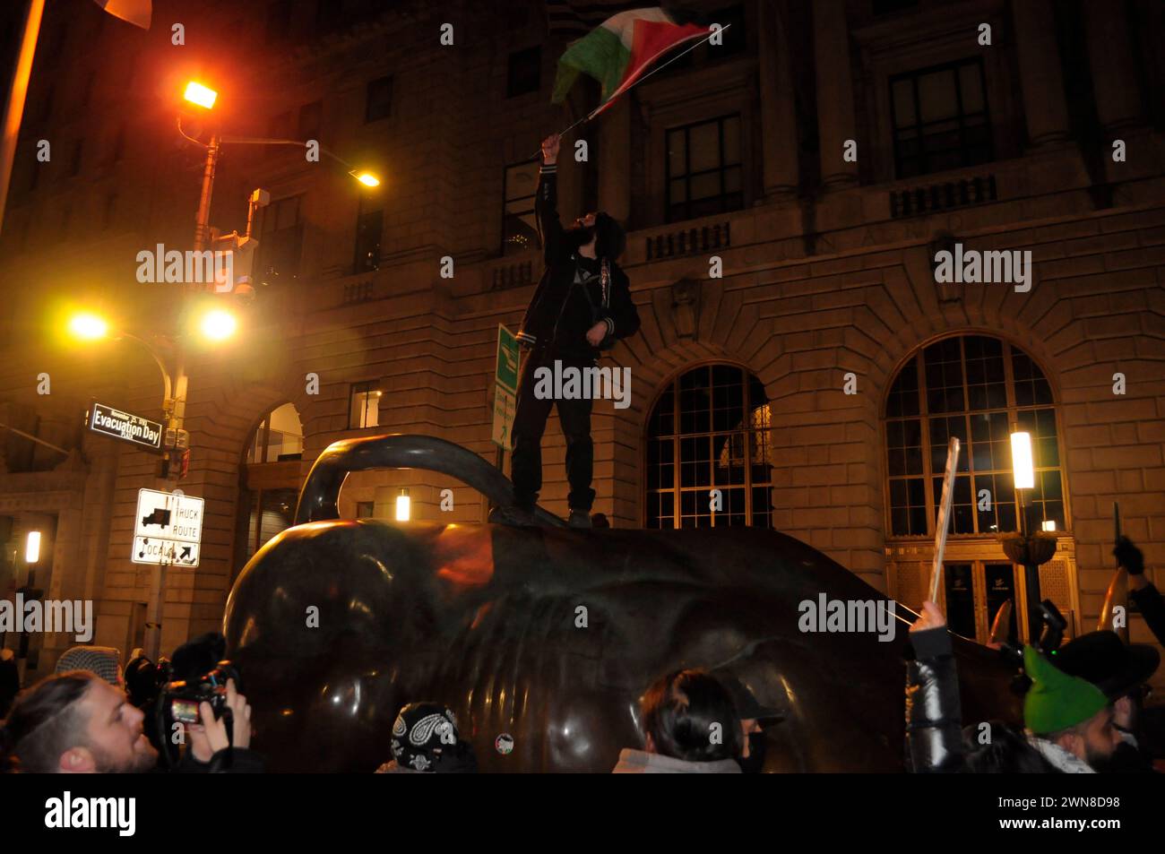 A pro-Palestine demonstrator waves the Palestinian flag while standing ...