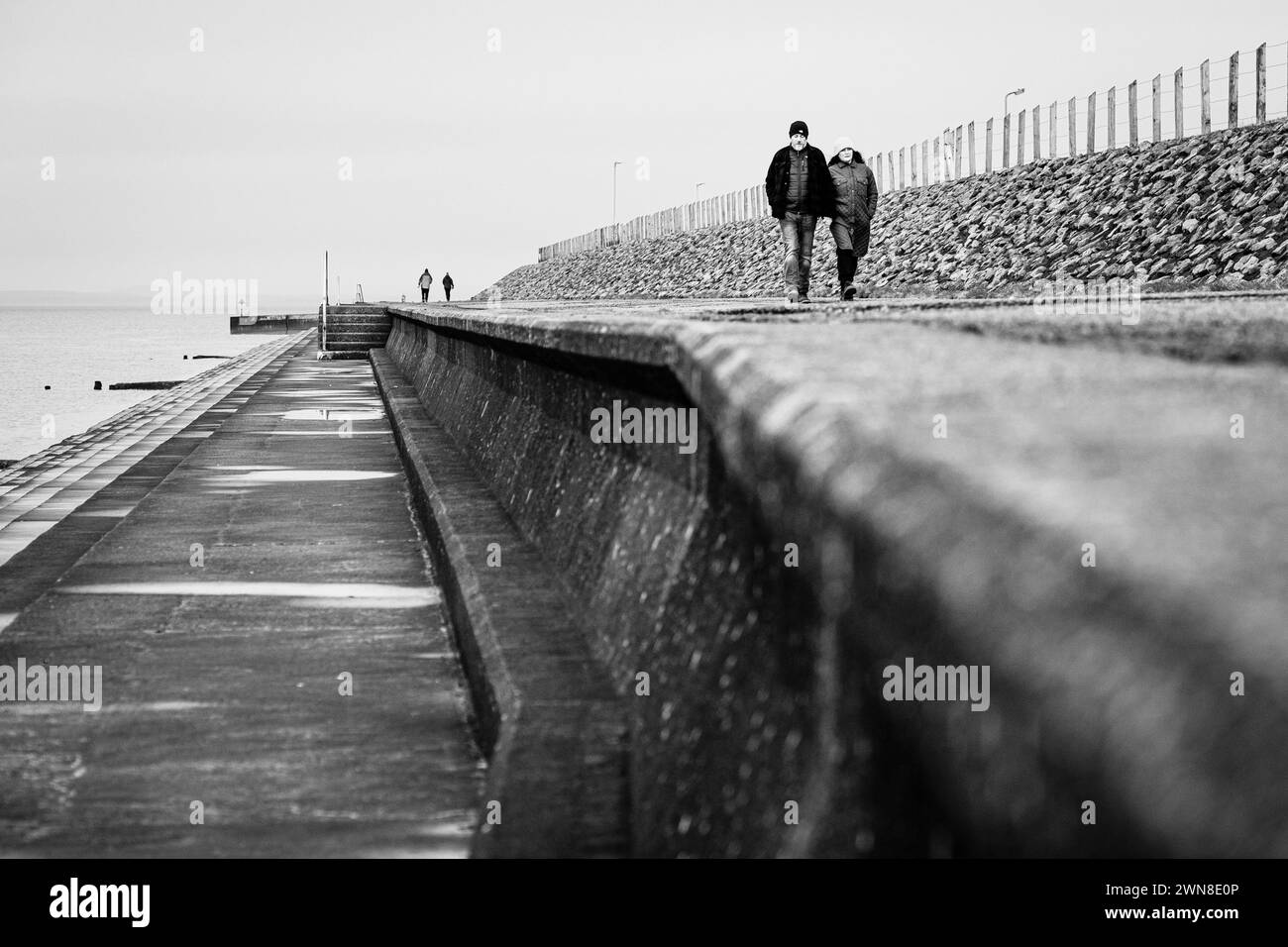 Walking along the sea defences at Silloth, Cumbria, England, UK Stock ...