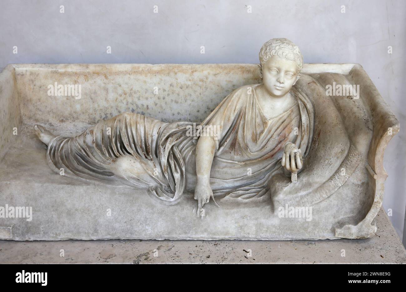 Roman sarcophagus with statue of reclining boy holding a fruit. Rome ...