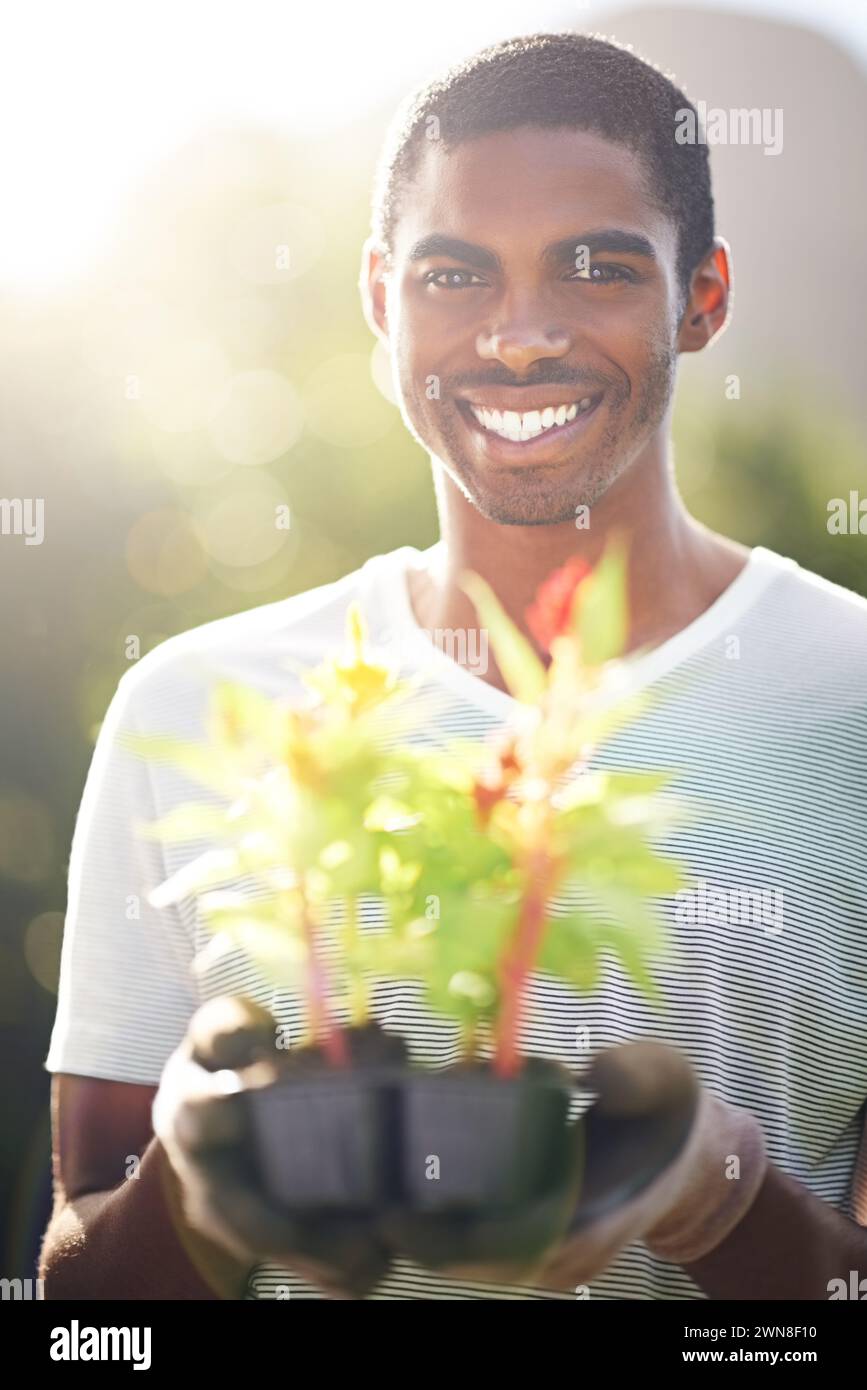 Portrait, happy and planting flowers with black man in garden of home ...