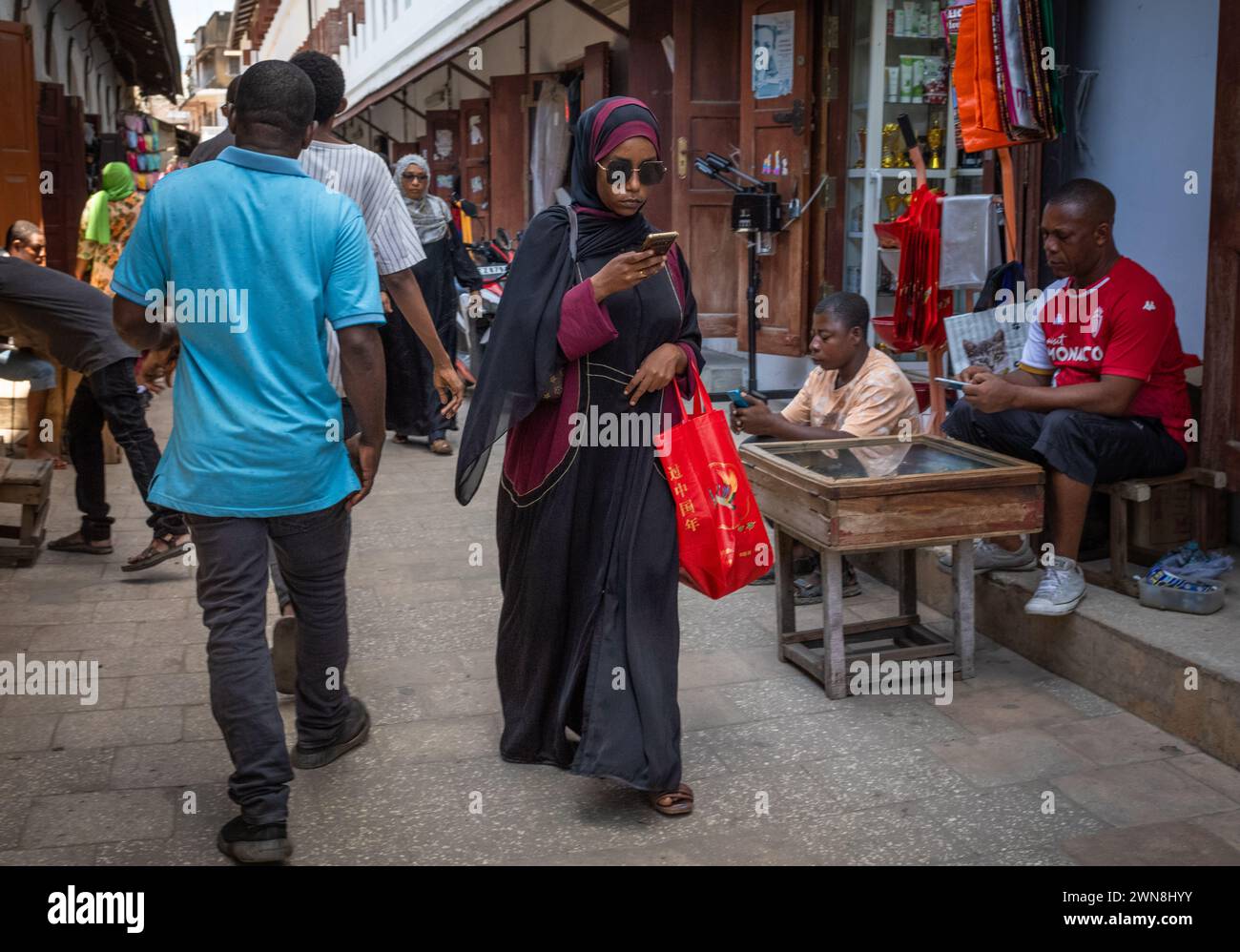A muslim woman wearing a traditional buibui and khimar shawl looks at ...