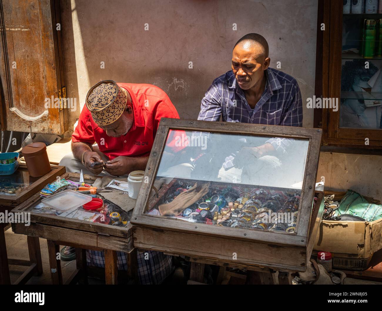 Two men work at a street stall repairing and selling watches in Stone ...