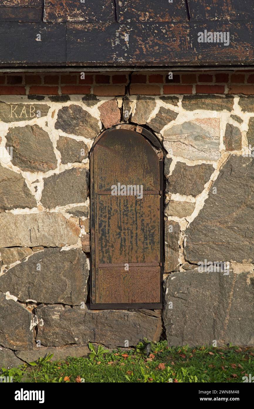 Old stone wall with weathered rusty metal door with arch Stock Photo ...