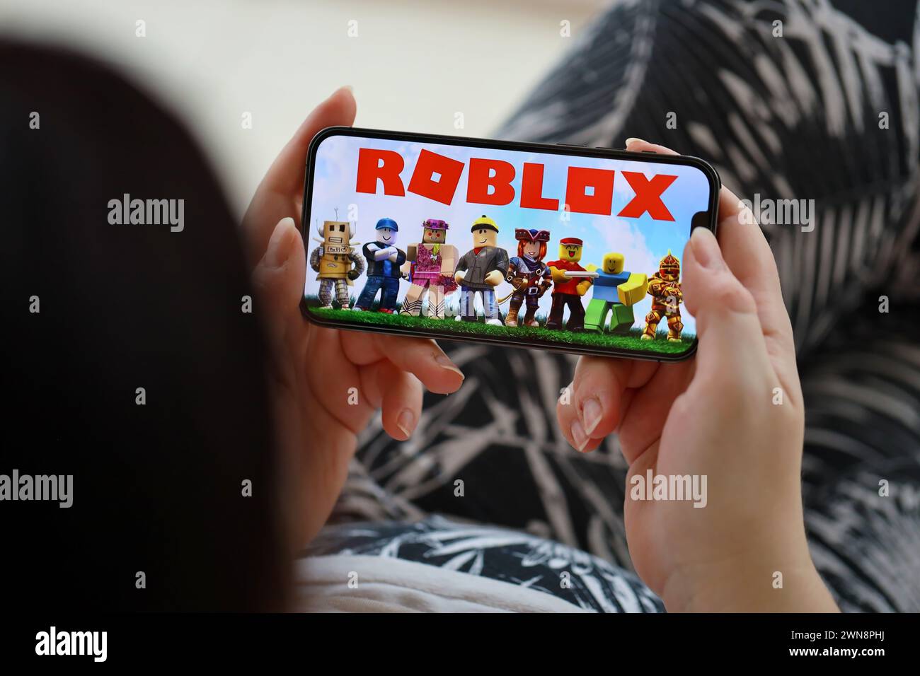 Roblox mobile iOS game on iPhone 15 smartphone screen in female hands ...