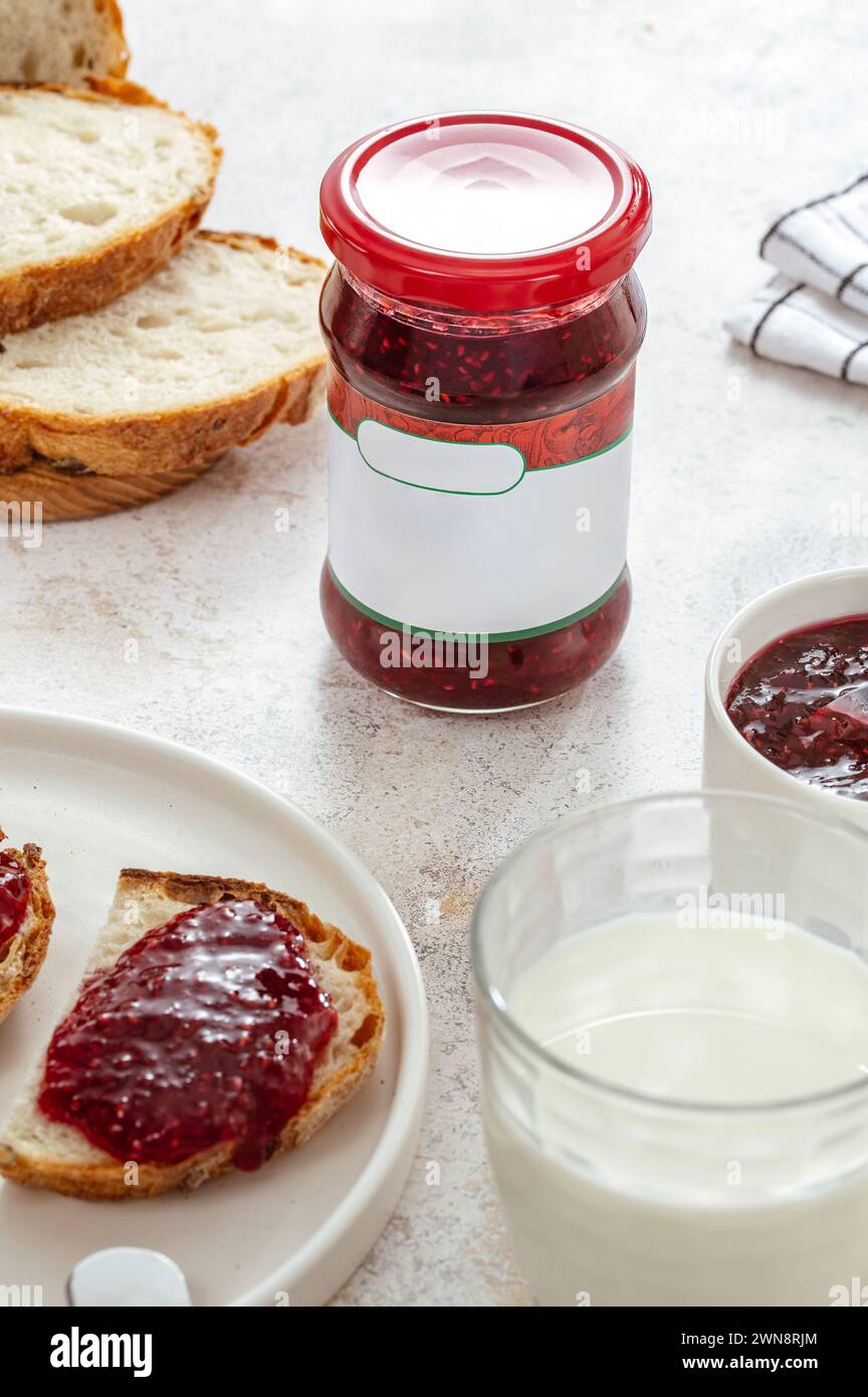 raspberry jam in a jar. bread with jam on a plate Stock Photo - Alamy