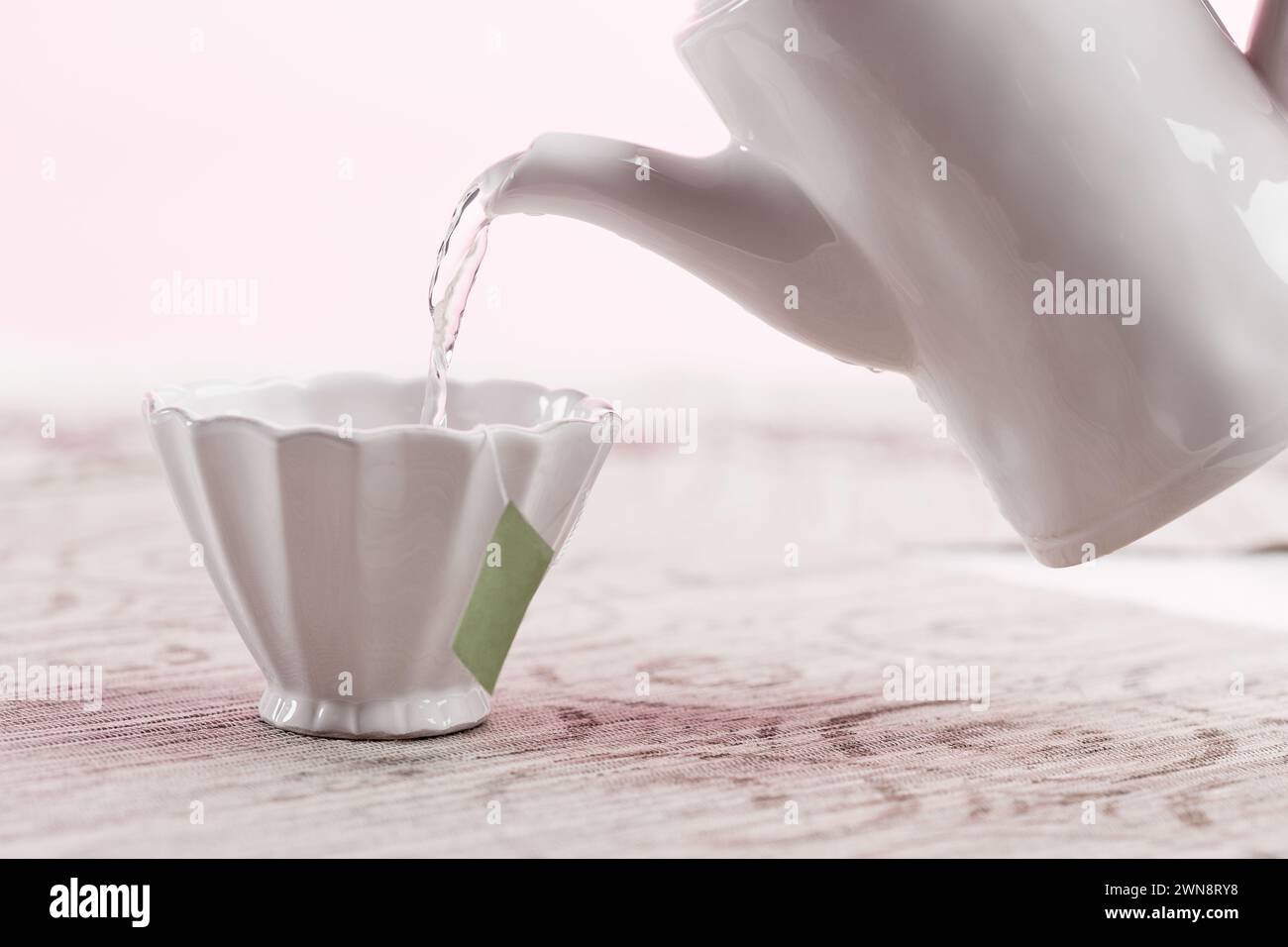 Elegant teapot pouring into tea cup Stock Photo - Alamy