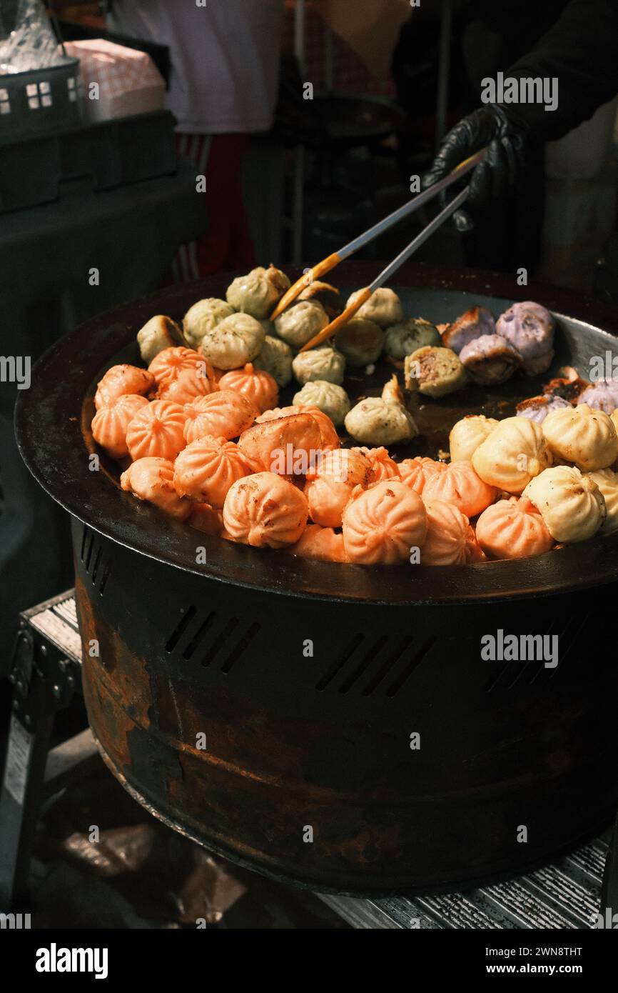 A worker cooks a large pot of bao at a street fair Stock Photo - Alamy