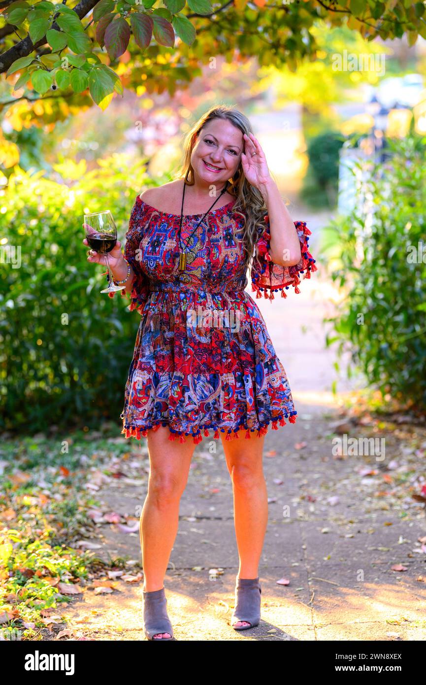 40 year old blond woman posing in a colorful dress outdoors Stock Photo ...