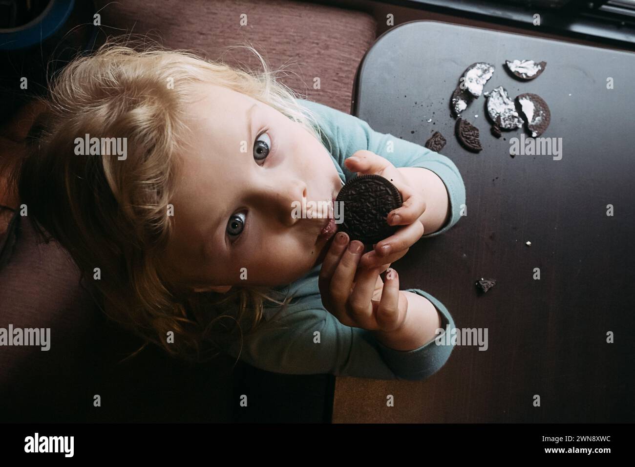 Child eating cream icing out of chocolate cookies Stock Photo - Alamy