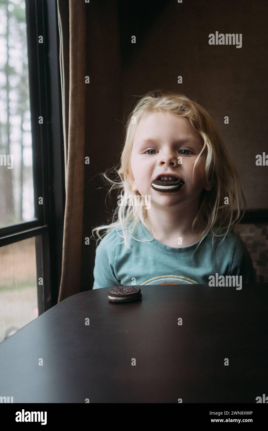 Child being silly while eating chocolate sandwich cookies Stock Photo ...