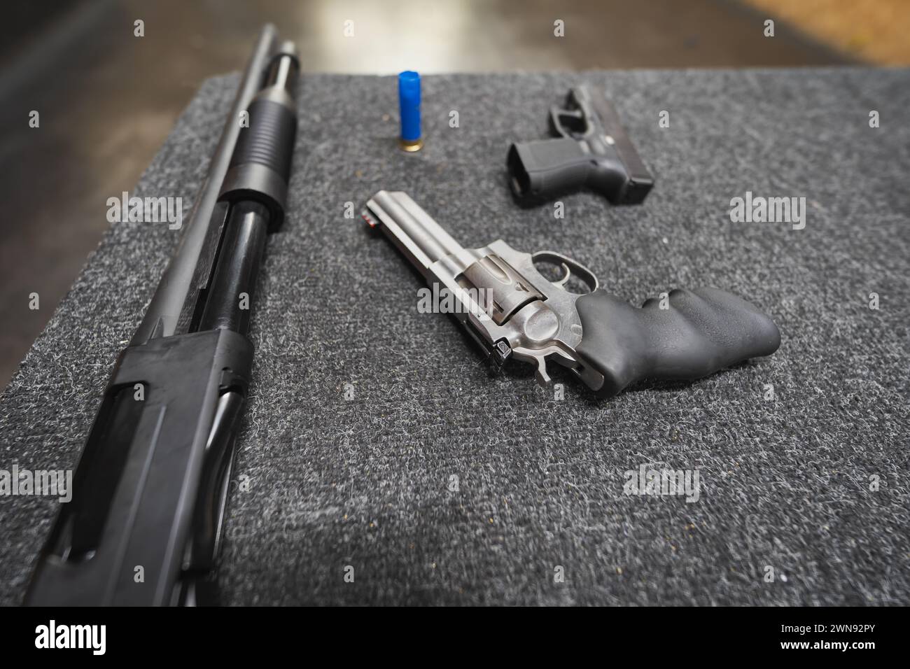 Firearms of various types in a shooting range. Pistol, revolver and ...