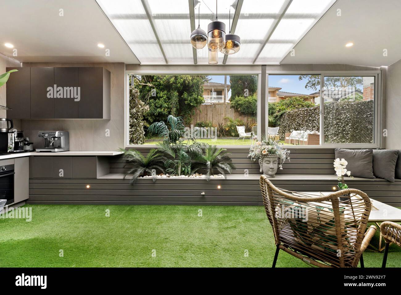A modern alfresco room with spacious windows showcasing green outdoor ...