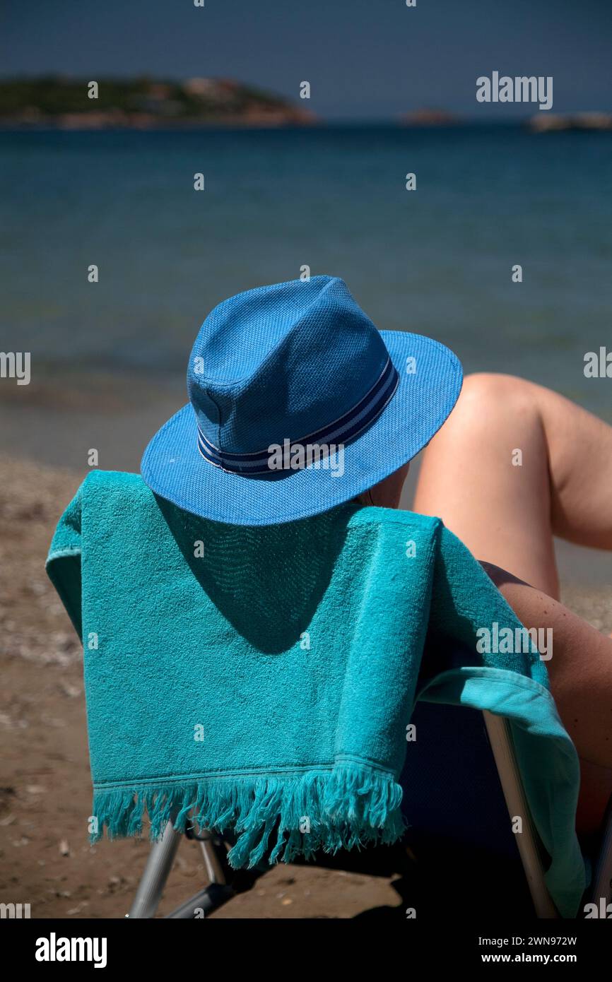 holidaymaker wearing straw hat on beach vouliagmeni athens riviera ...