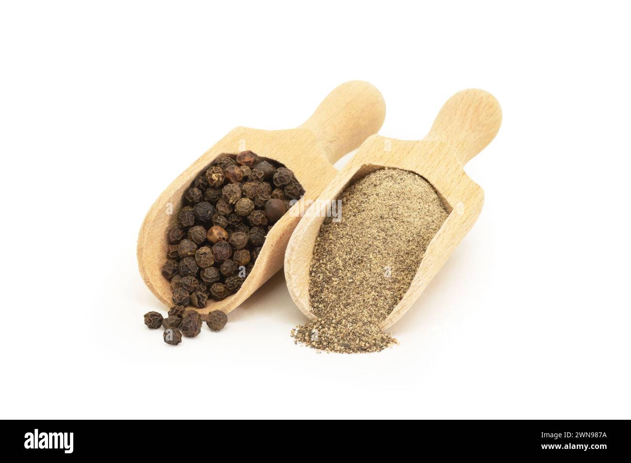 Heap of black pepper, peppercorns in spoon with milled powder isolated ...