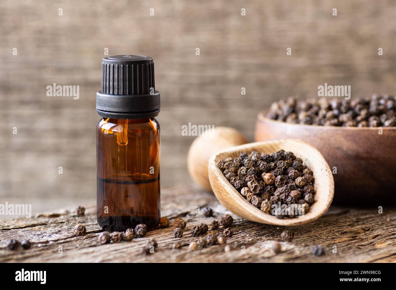 Glass Bottle of black pepper essential oil with peppercorns ...
