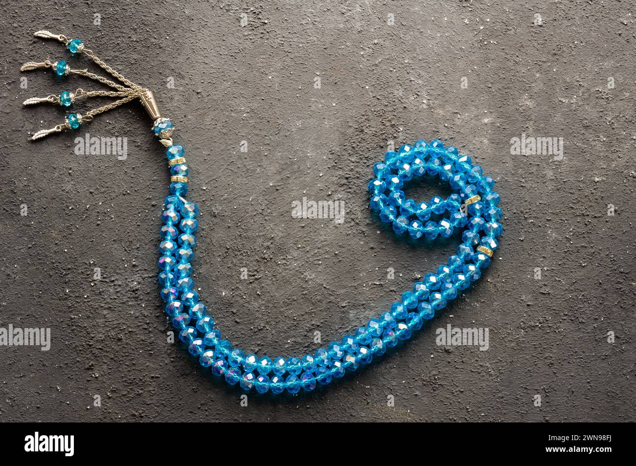Arabic letter wav made with blue rosary on gray rustic background ...