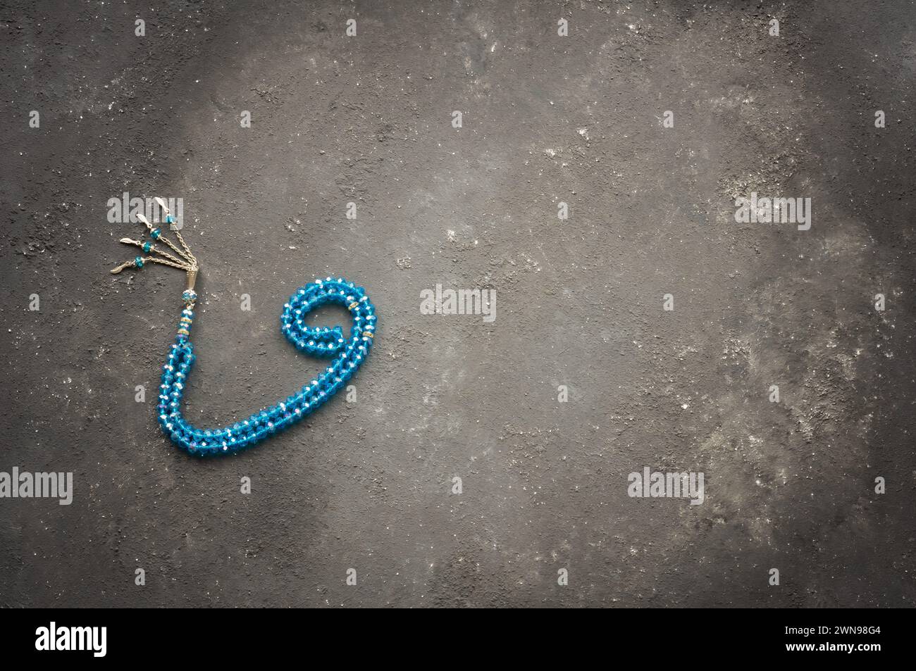 Arabic letter wav made with blue rosary on gray rustic background ...
