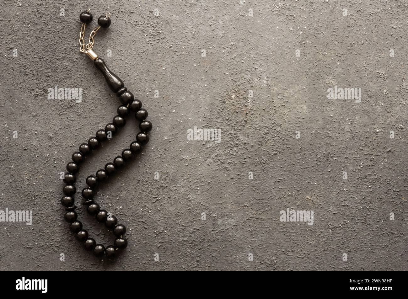Black beads Muslim prayer rosary on dark stone background, symbol of ...