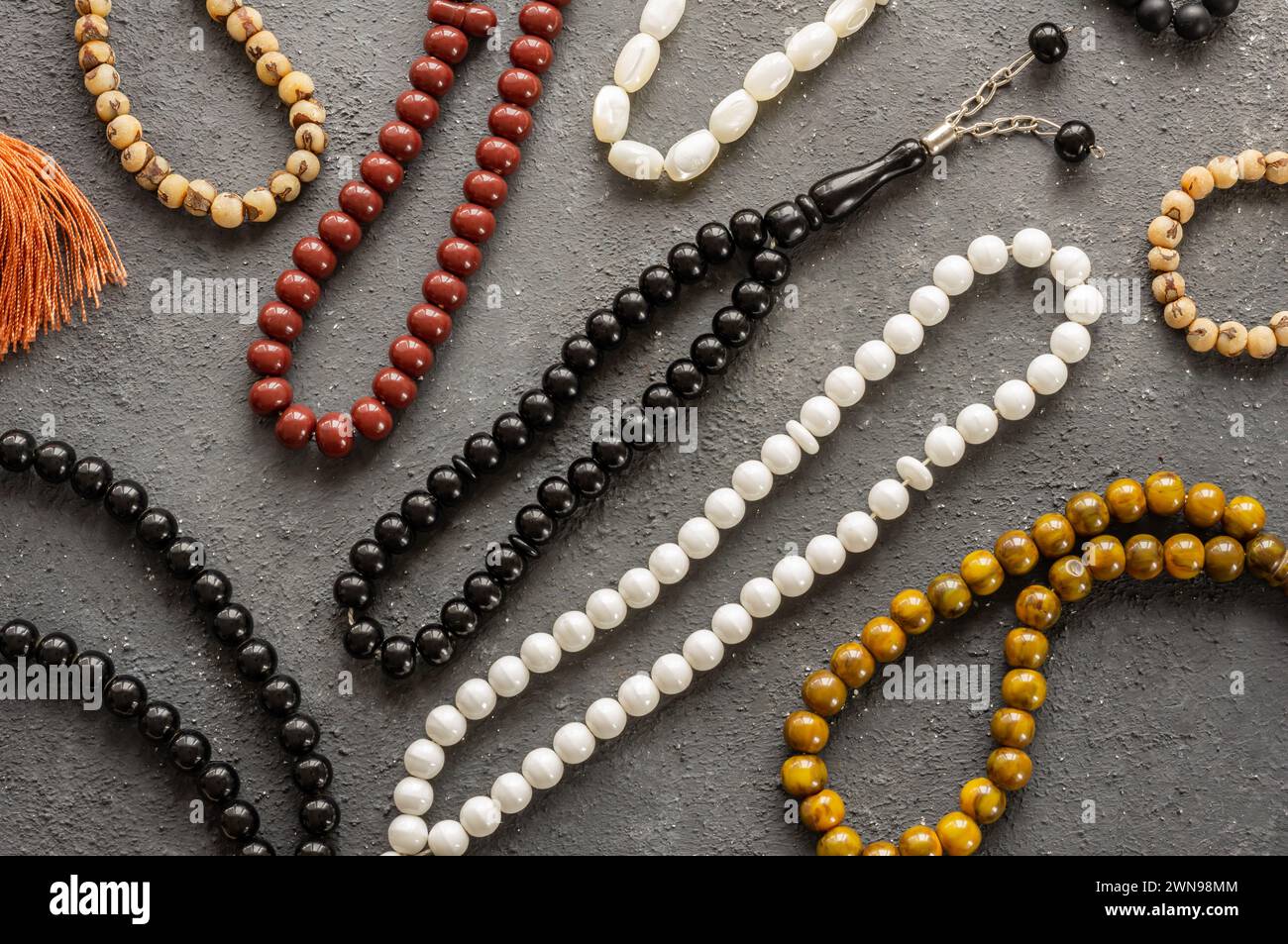 Several muslim prayer rosary on dark stone background, symbol of islam ...
