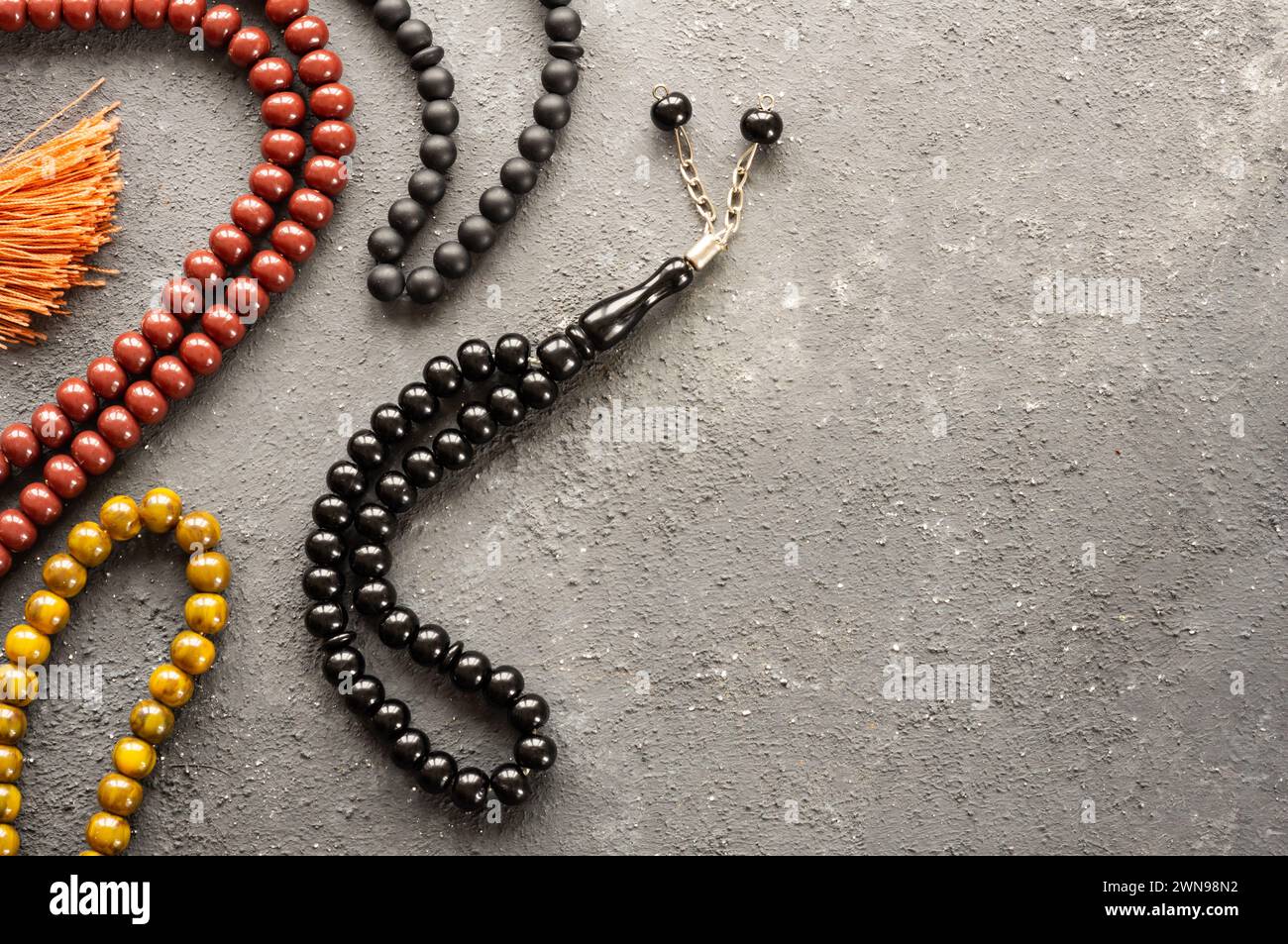 Several muslim prayer rosary on dark stone background, symbol of islam ...