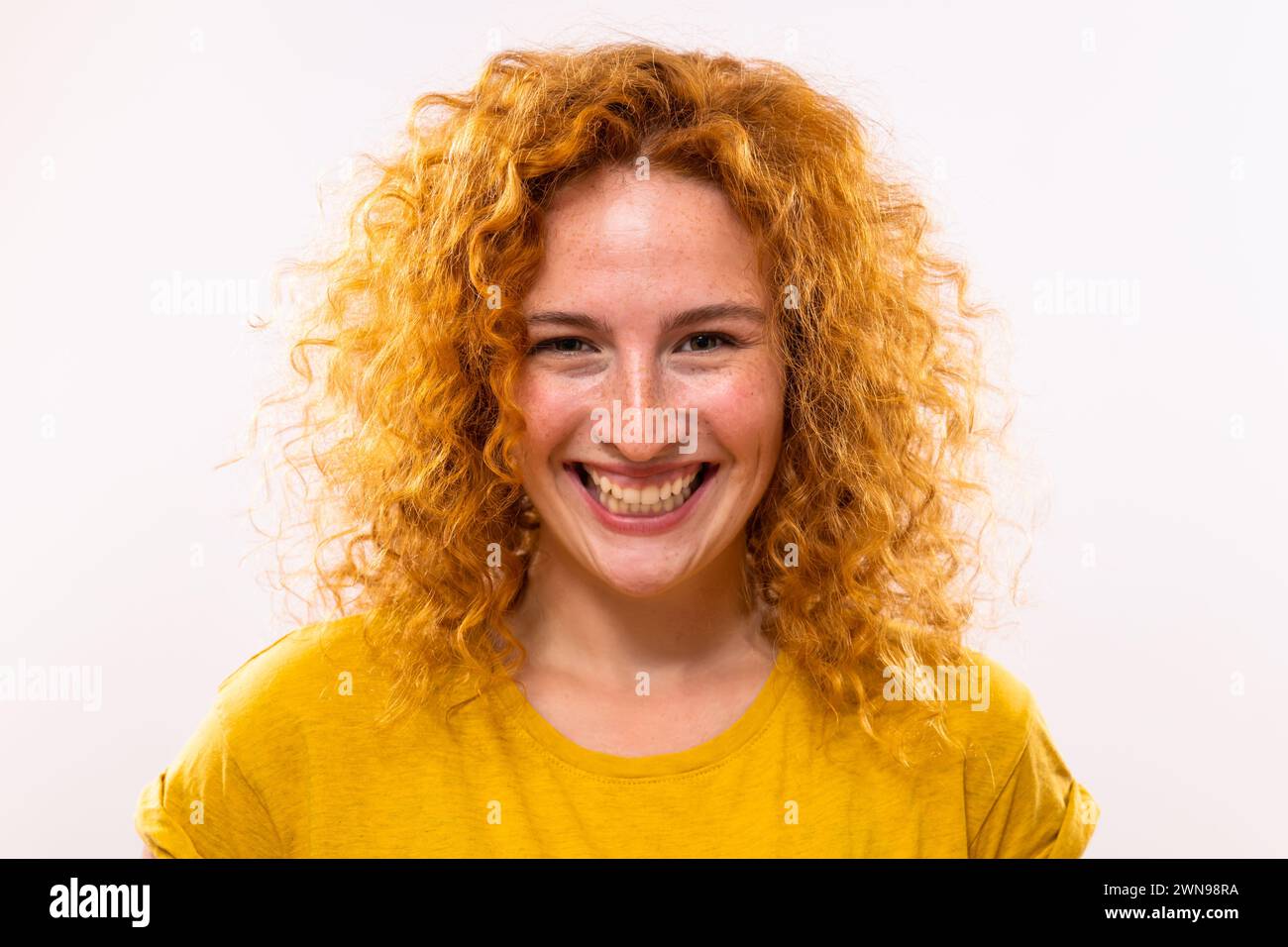 Close up portrait of happy ginger woman with freckles and curly hair ...