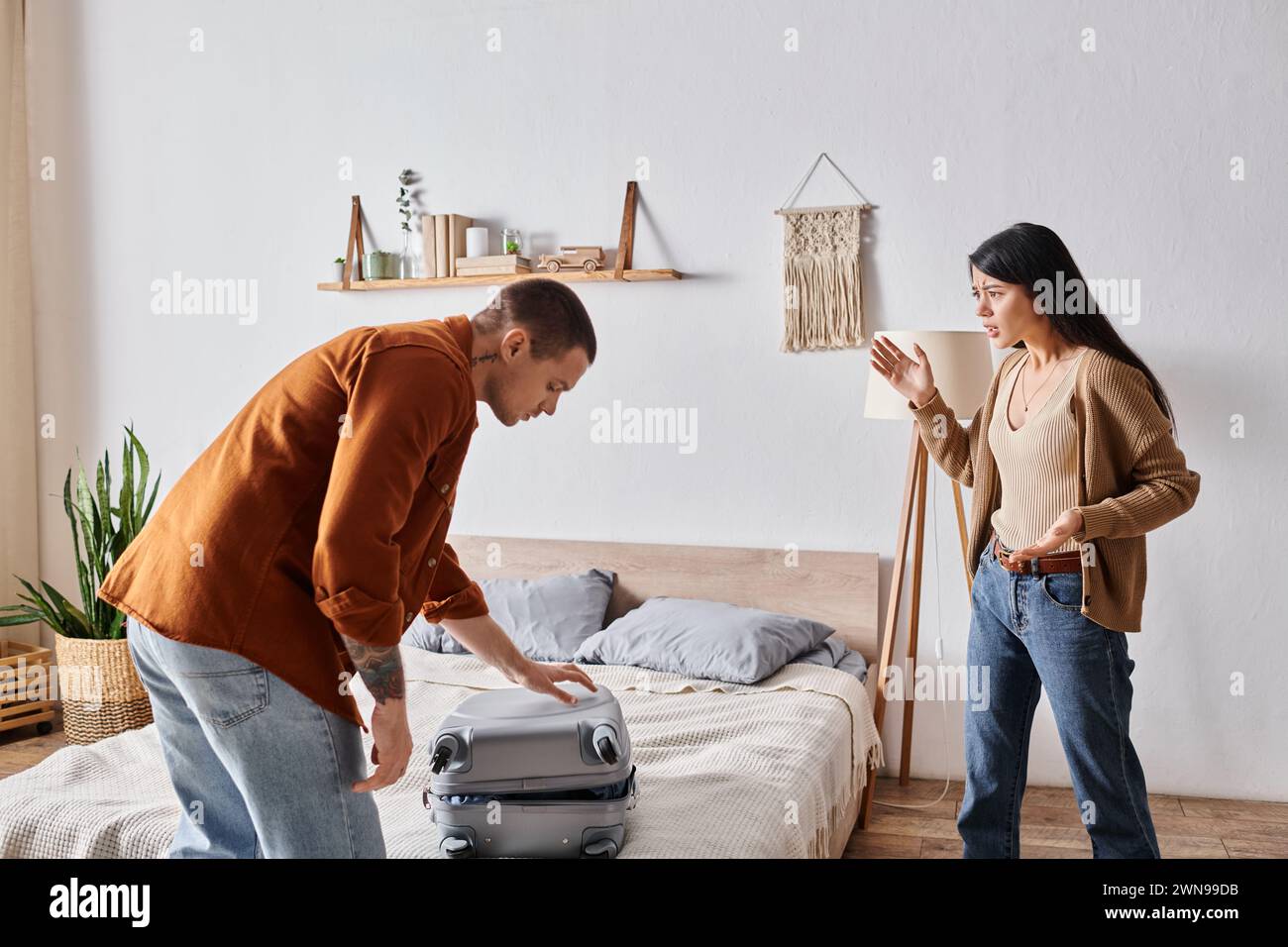 angry asian woman quarreling at husband packing suitcase in bedroom ...