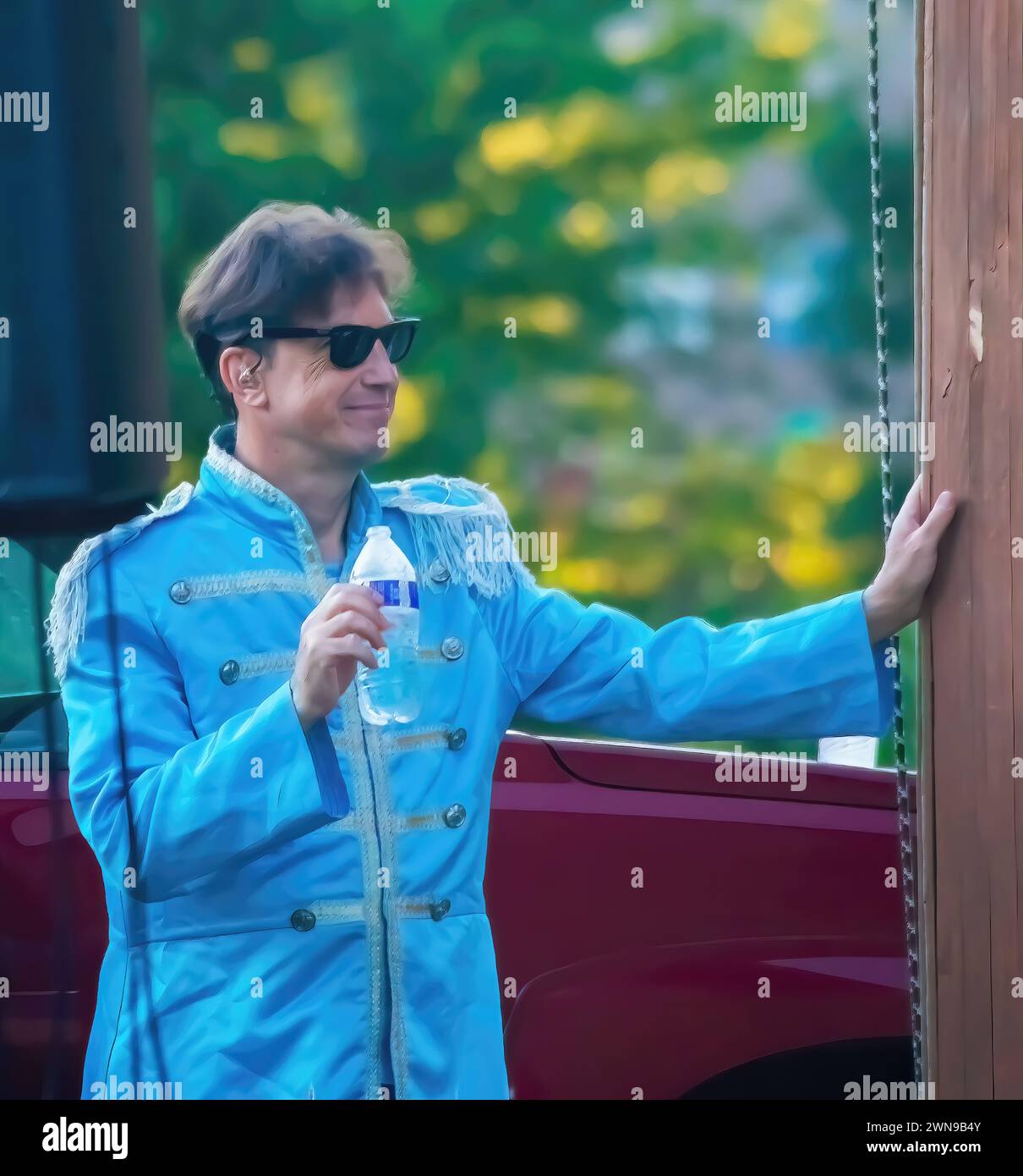 Musician in a Beatles costume taking a break during a performance in ...