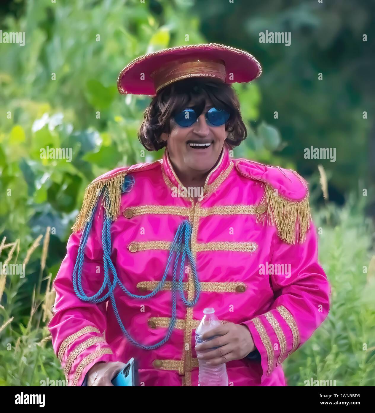 Musician in a Beatles costume taking a break during a performance in ...