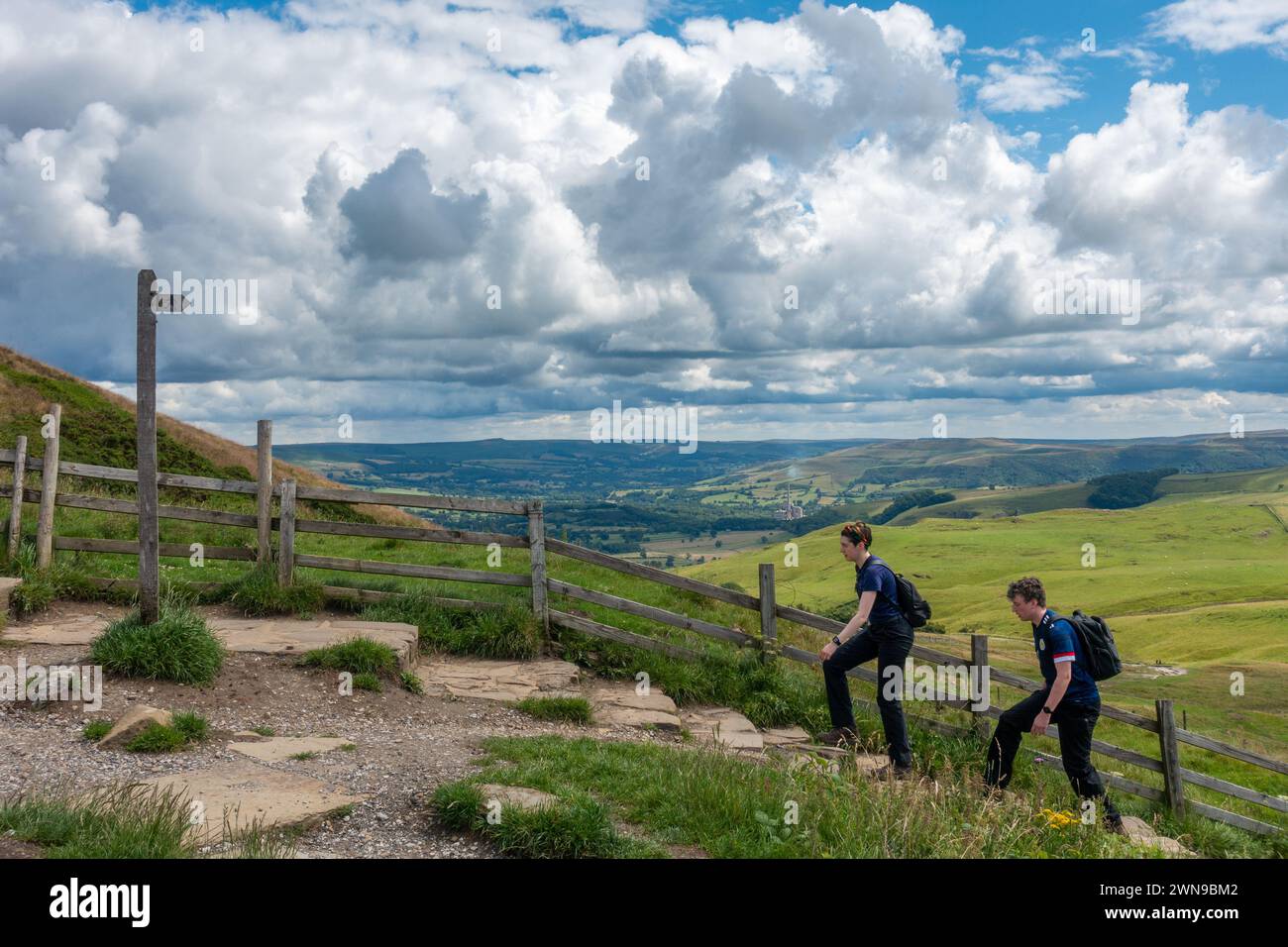 Two walkers walking up the steep steps on the way to Mam Tor on a ...