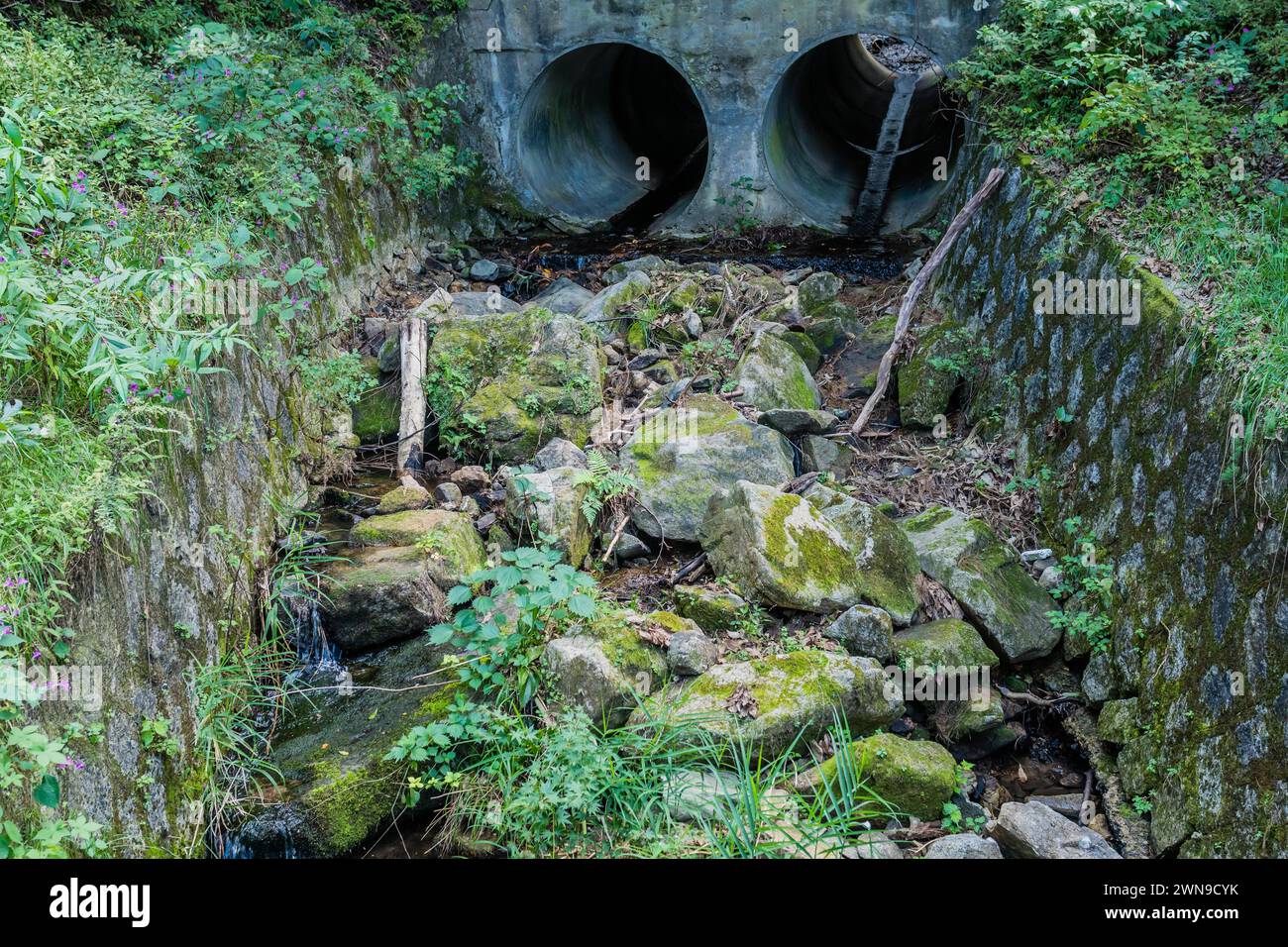 Double culvert at end of man made ditch filled with large boulders in ...
