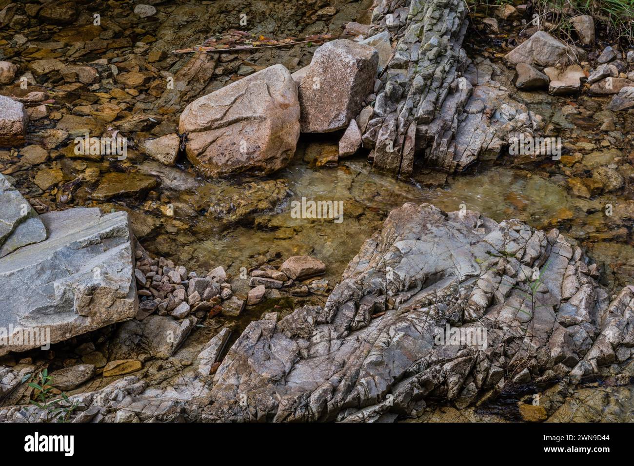 Large jagged boulders in shallow mountain stream in wilderness park in ...