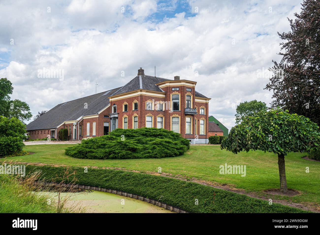 A magnificent manor house with a tiled roof and well-tended garden ...