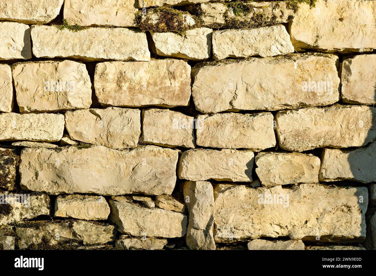 Dry masonry, wall made of natural stones in the evening light ...