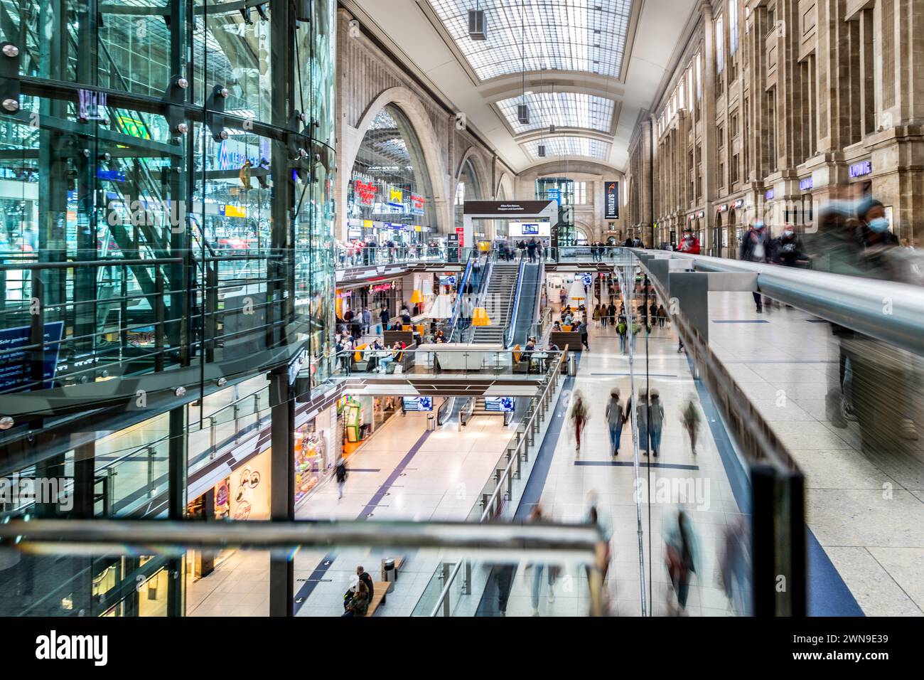 Lively atmosphere in the modern railway station with glass facade and ...
