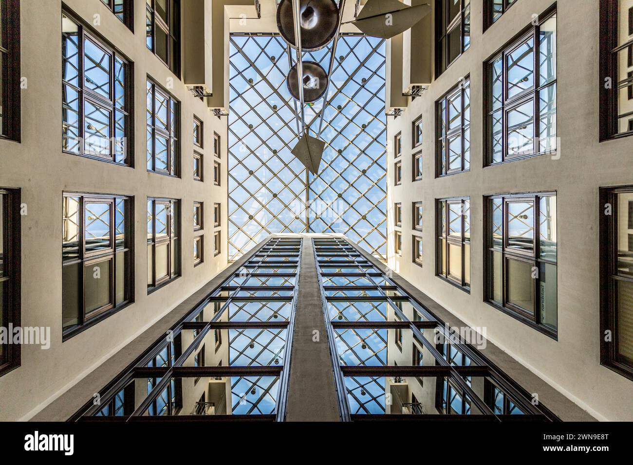 View upwards into a symmetrical inner courtyard with windows and a ...