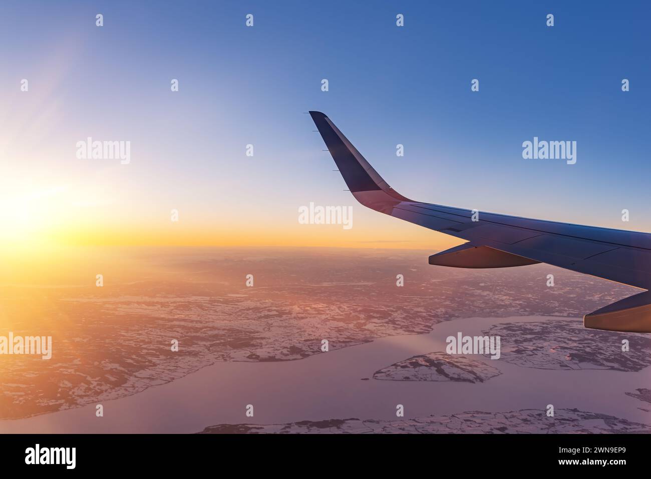 Airplane flying low over snowy mountains and preparing for landing to ...