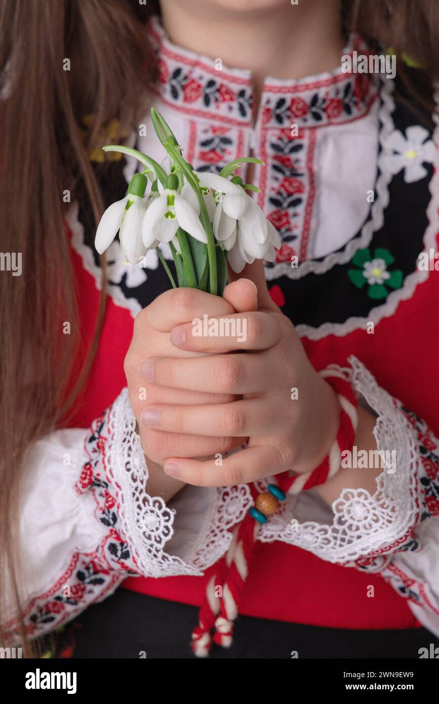 Bulgarian girl in traditional folklore costumes with spring flowers ...