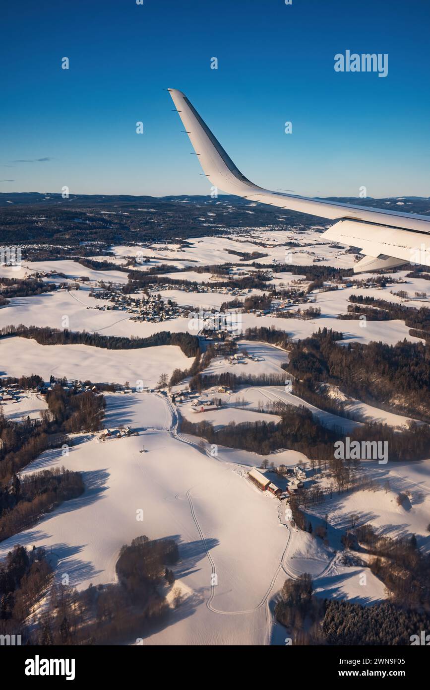 Airplane flying low over snowy mountains and preparing for landing to ...