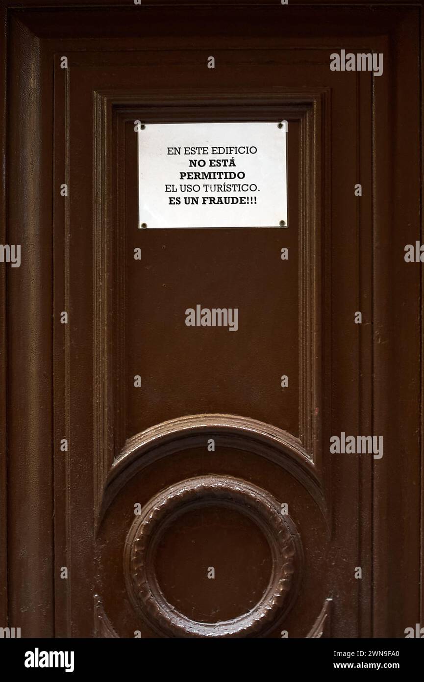 Image of a warning sign stuck on a brown door indicating the ...