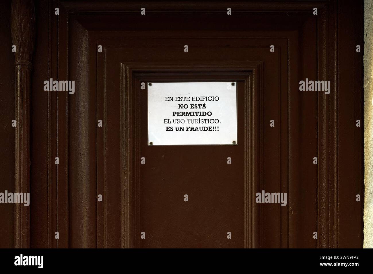 Image of a warning sign stuck on a brown door indicating the ...