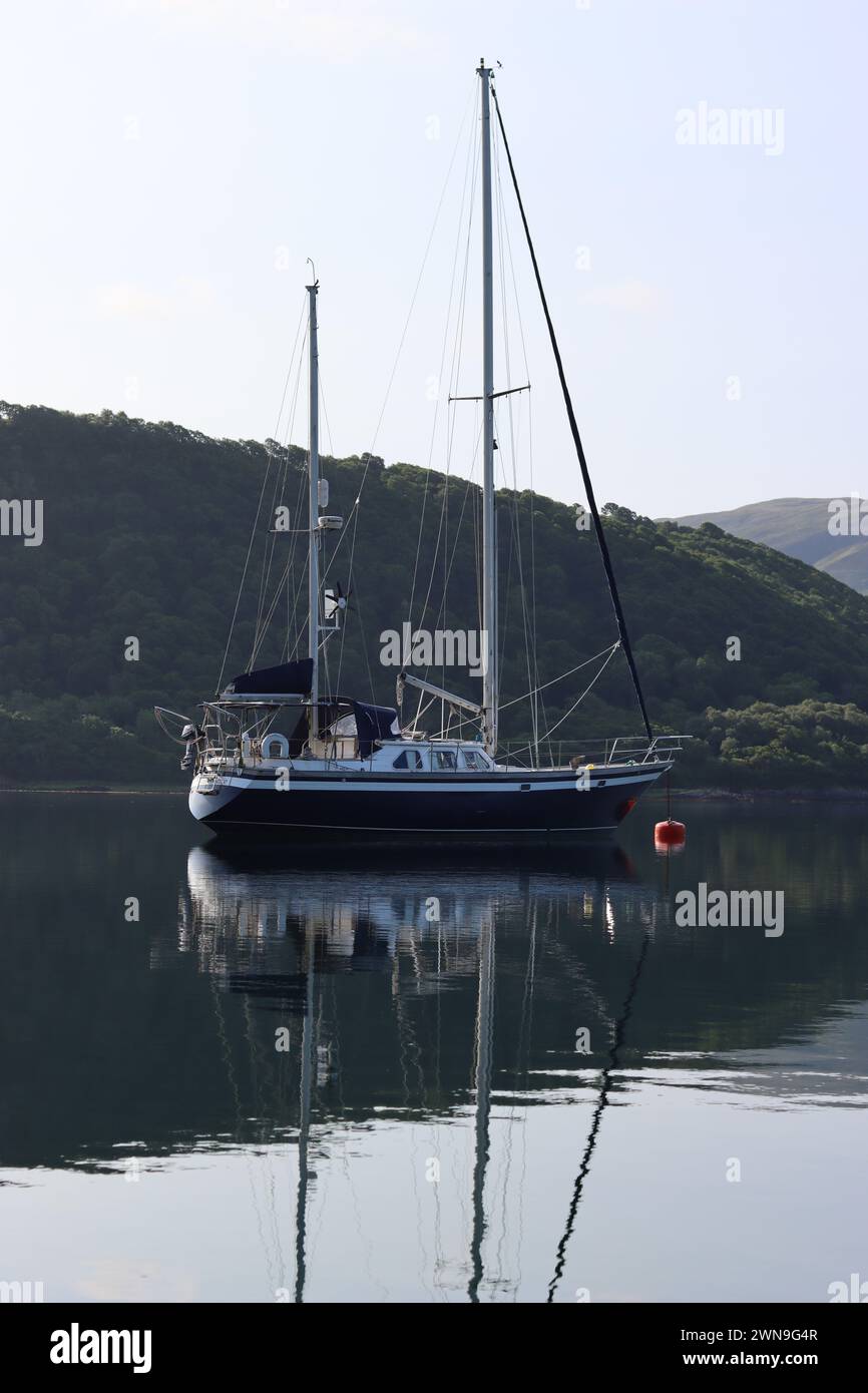 Sailing yacht on a still sea loch Stock Photo - Alamy