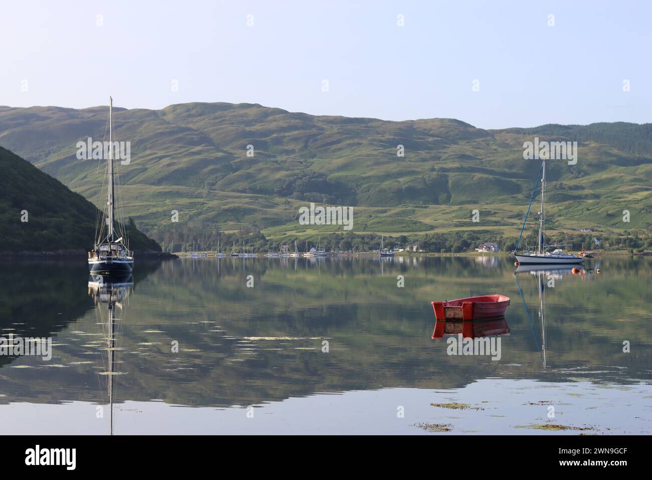 Boats on a still sea loch in sunshine Stock Photo - Alamy