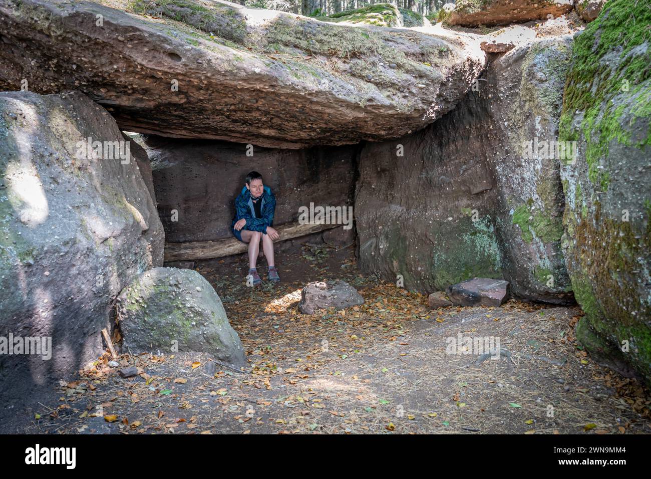 Path of the Gauls. View of a hiker woman sitting in the druids' cave ...