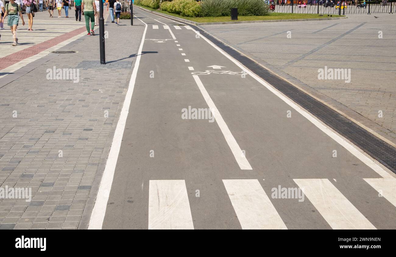 A sign of a bicycle path and pedestrian crossing on the asphalt in a ...