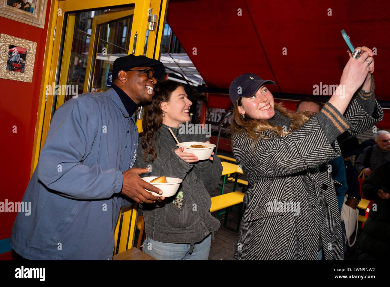 Ian Wright poses with customers as he hands out 100 pies to launch his ...