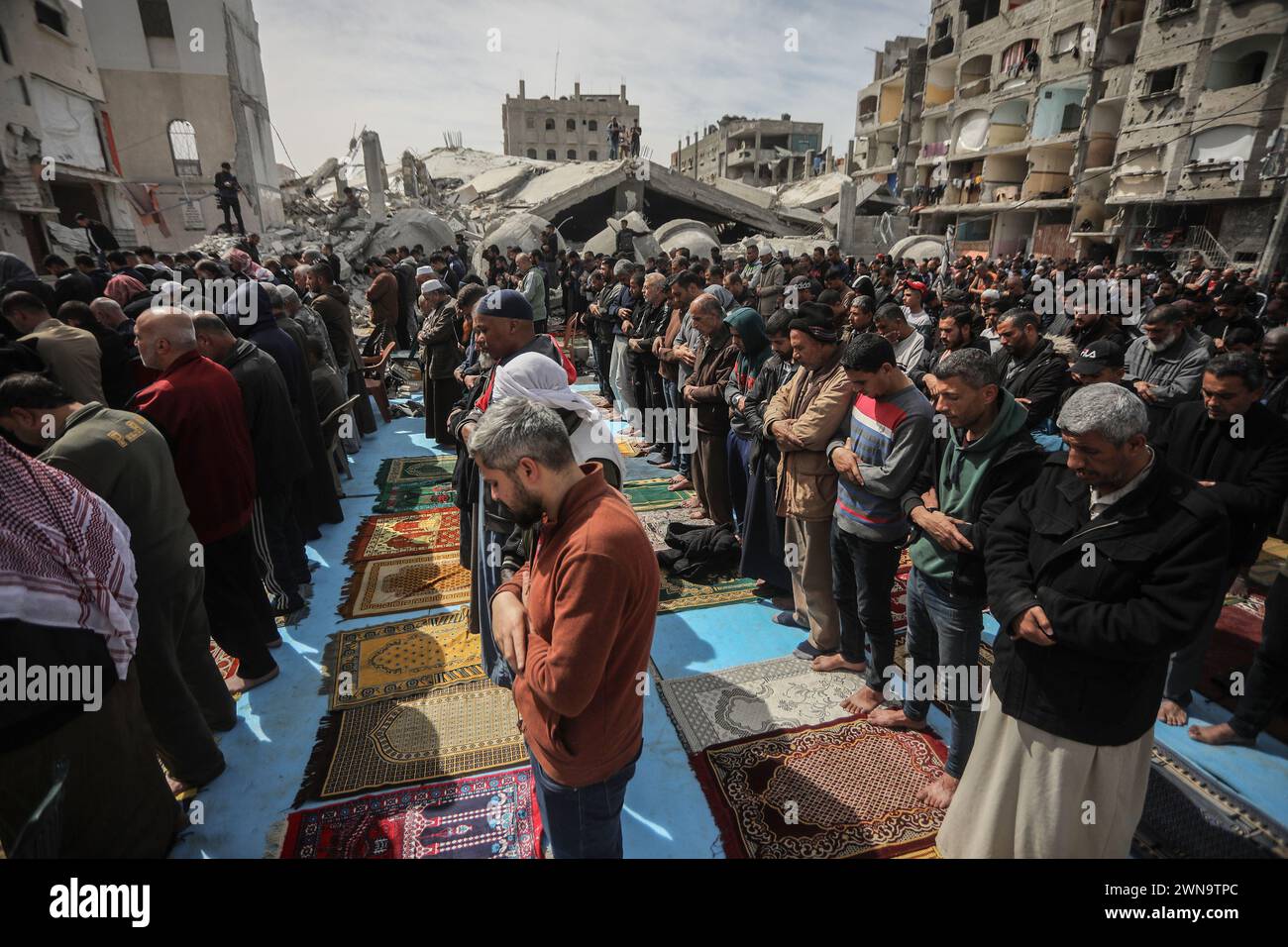 Palestinians attend Friday prayers near the ruins of a mosque destroyed ...