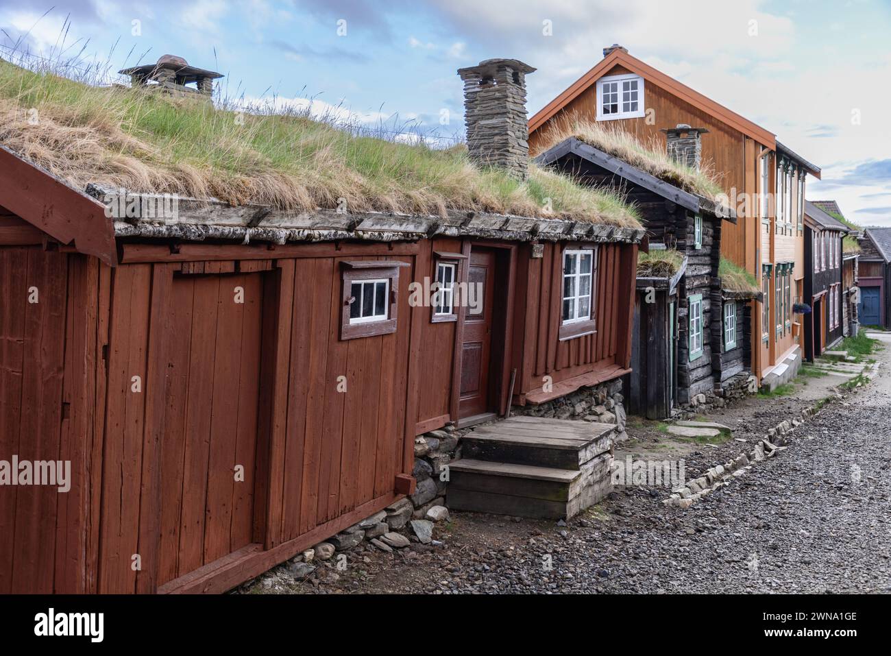 Rustic wooden cabins with turf roofs in Roros lead the eye down a ...