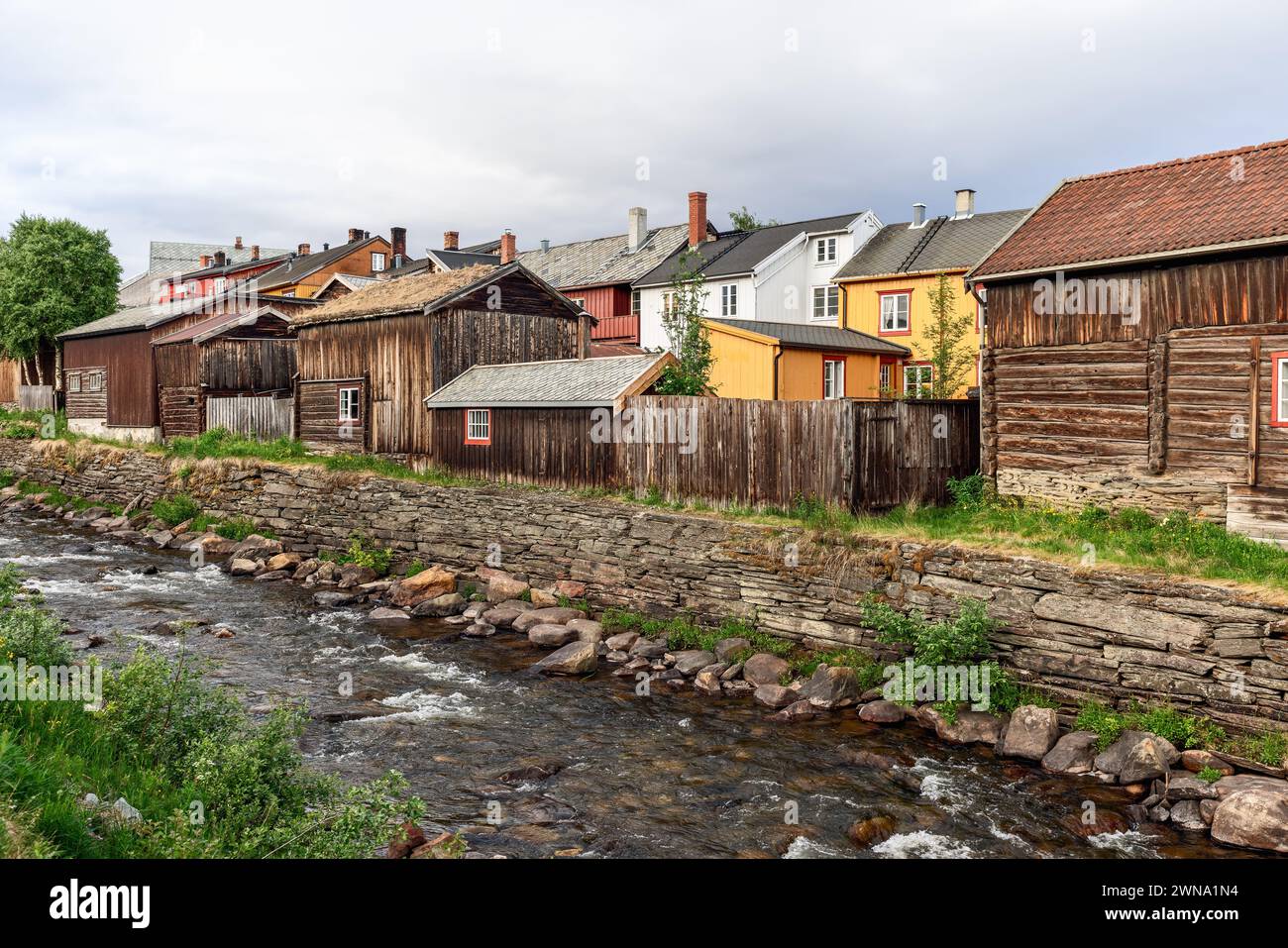 A tranquil scene at Roros with the Glomma River flowing past historical ...